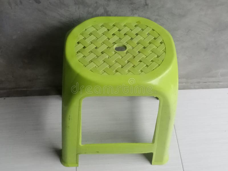 A Green Plastic Stool with a Woven Seat. the Stool is Simple and Has a ...