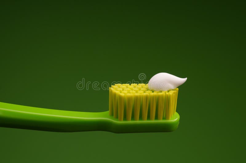 Green Plastic Toothbrush with White Toothpaste on a Green Background ...