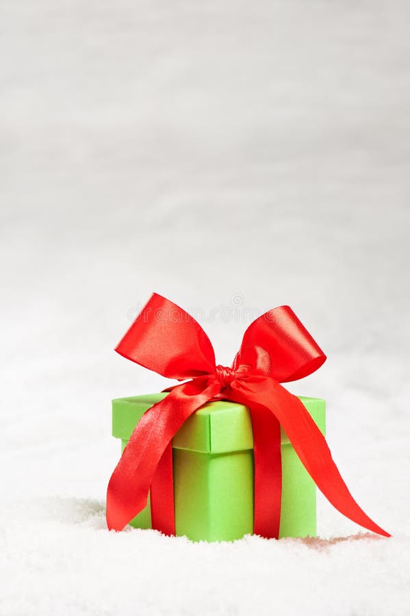 Green Present with Red Ribbon Over Snow Stock Photo - Image of modern ...