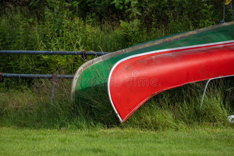 Green and Red Canoes in Storage Near a Lake.. Stock Image - Image of ...