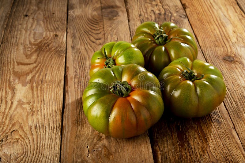 Green Ribbed Tomatoes on a Rustic Background Stock Image - Image of ...