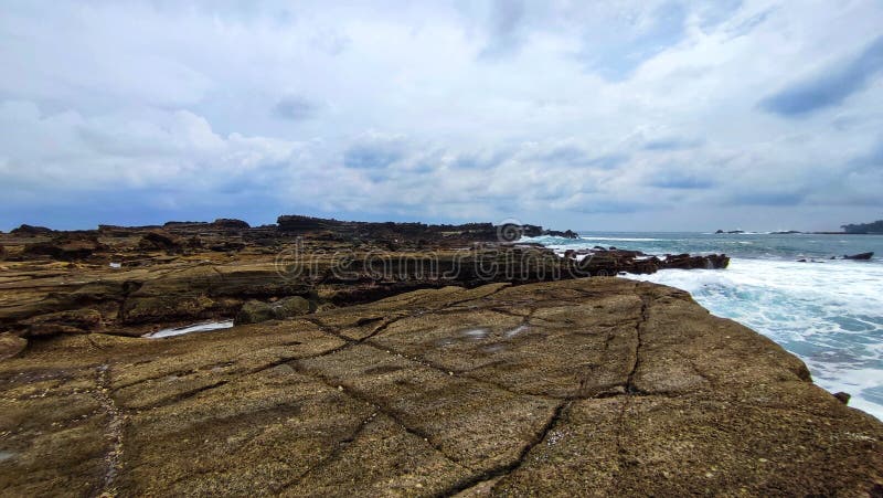 Green Rocks on the Edge of a Blue Beach Stock Photo - Image of ...