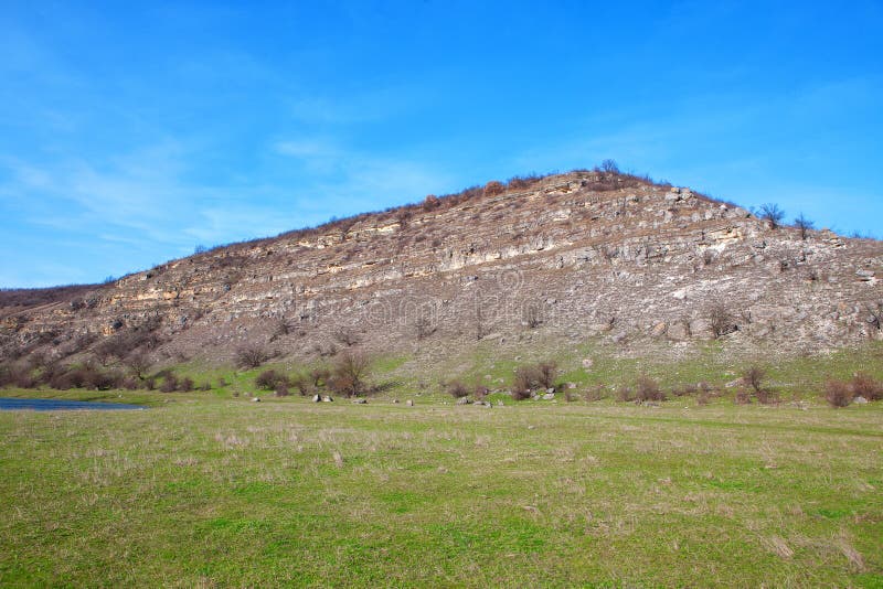Green rocky hill stock image. Image of building, blue - 158124351