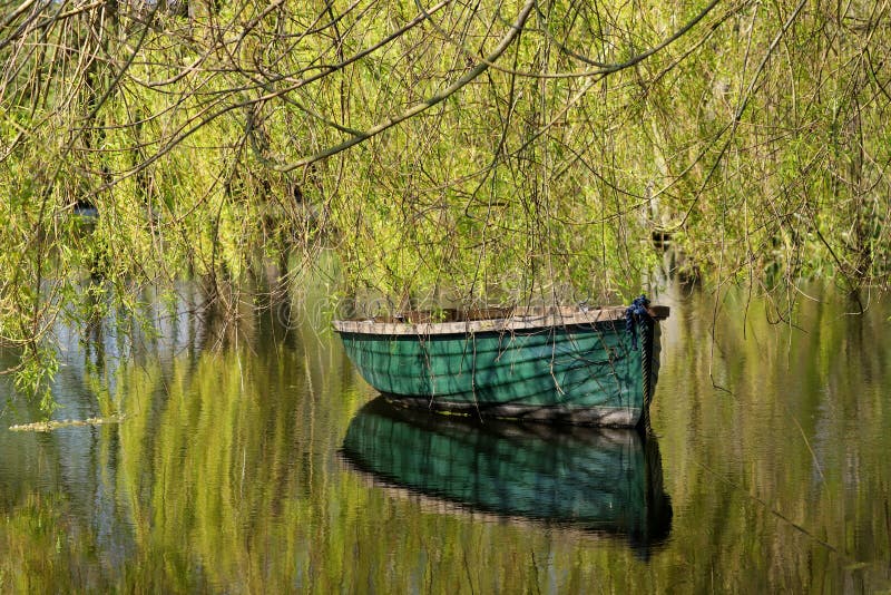 Green Rowing Boat on a Still Pond with Reflection in the Water Stock ...