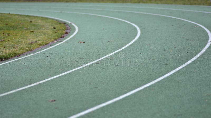 Green Running Track with White Lines and Green Grass in the Sides Stock ...