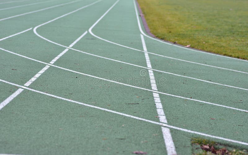 Green Running Track Turning with White Lines and Grass in Right Side ...