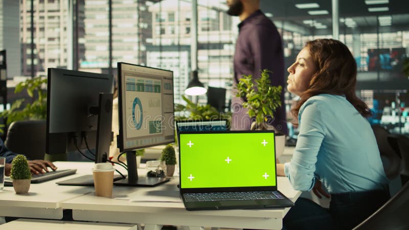 Green Screen Laptop on Office Desk Next To Employee Editing Documents ...