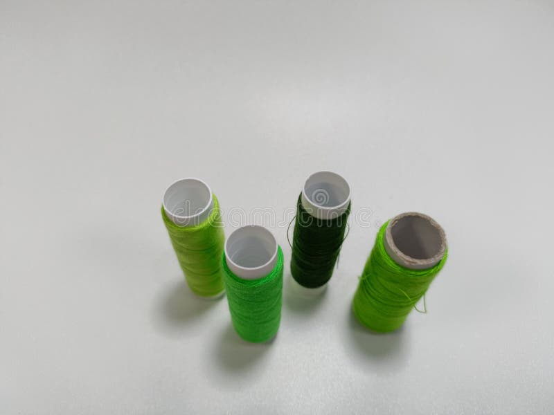 Green Sewing Thread Spools in Vertical Arrangement on White Background ...
