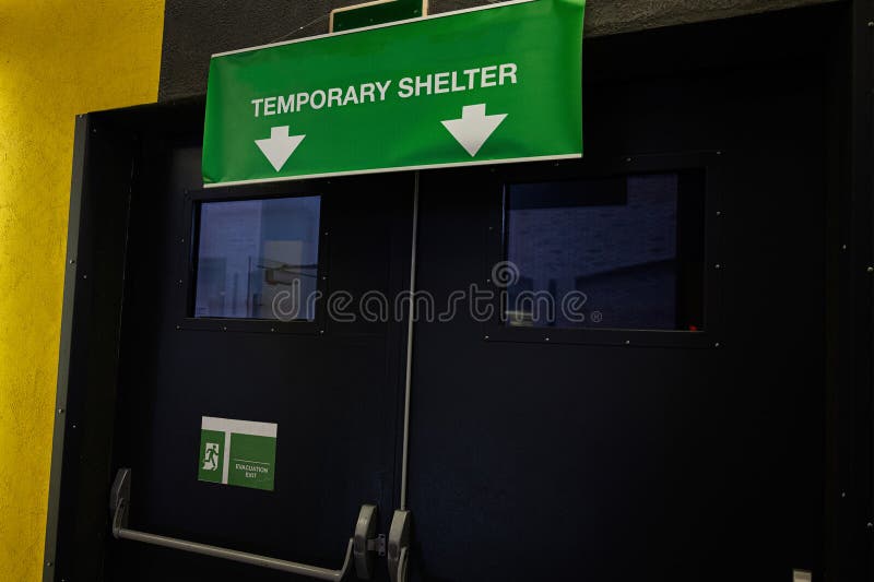 Green Sign Indicating Temporary Shelter Found Above Emergency Exit Door ...