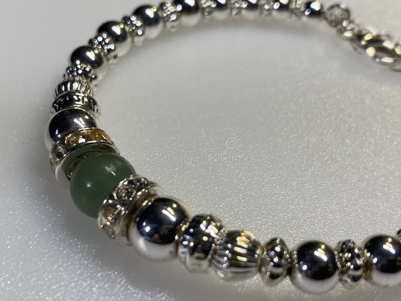 A Green and Silver Bead Bracelet is Shown on a Table Stock Photo ...