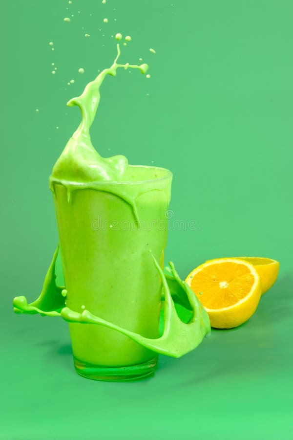 A Green Smoothie with a Splash of Green and Lemon on a Green Background ...