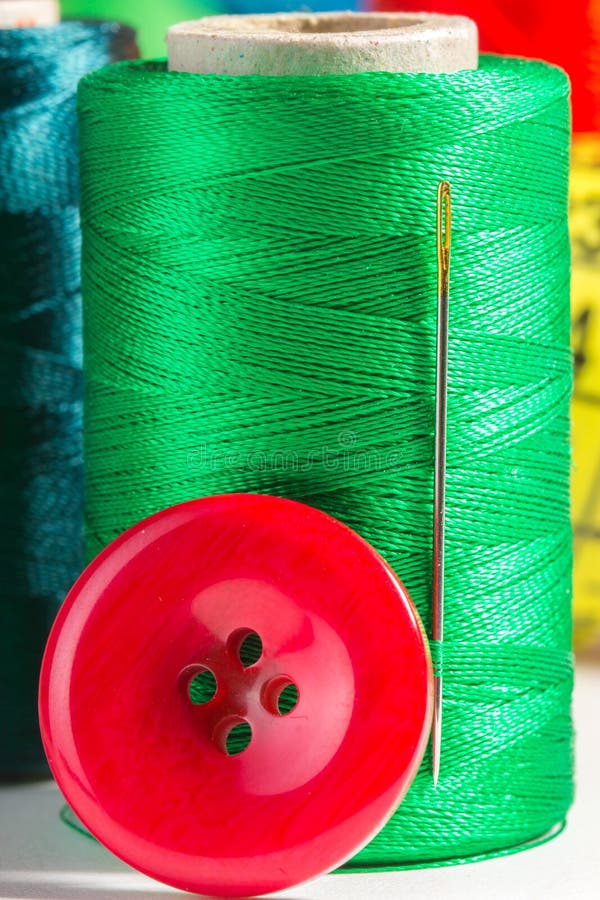 Green Spool of Thread with Needle and Button Stock Photo - Image of ...