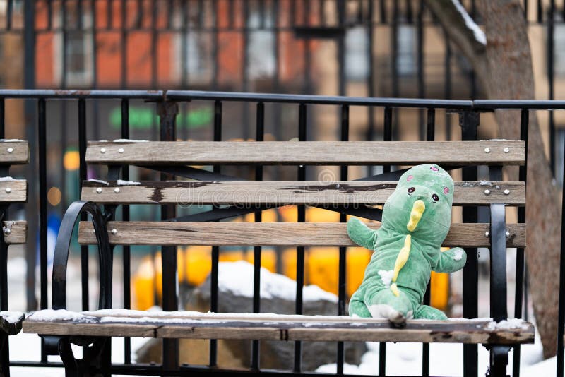 A Green Stuffed Animal is Sitting on a Bench in the Snow Stock Image ...