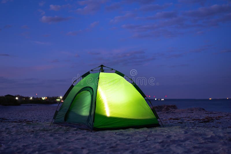 Green Tent Glows from the Inside at Night. Camping on the Beach Stock ...