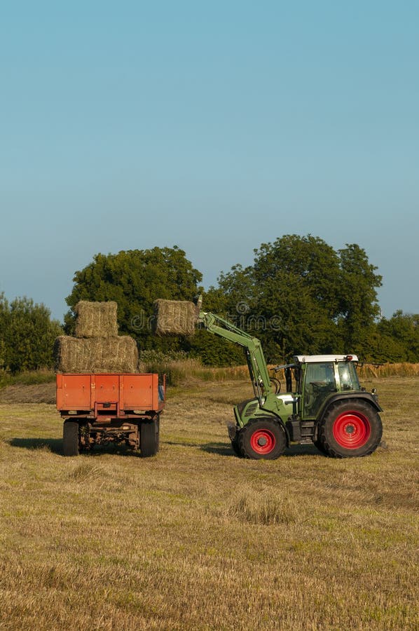 Tractor Loading Hay Bales on a Trailer Stock Image - Image of machinery ...