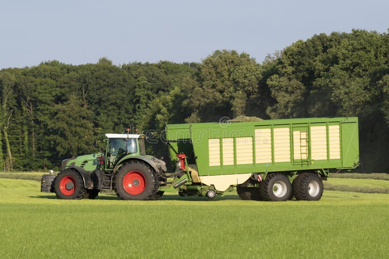 Green Tractor Picking Up Cut Grass Stock Image - Image of machine ...
