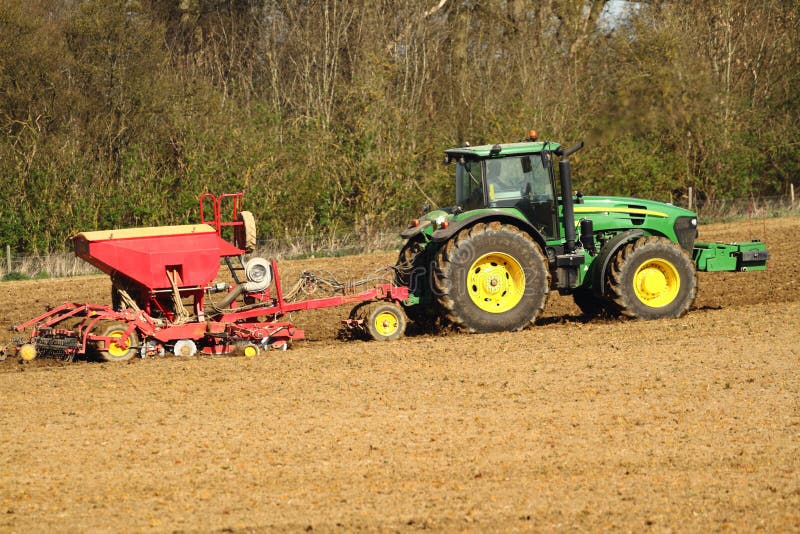 Green tractor sowing seeds editorial stock image. Image of crops - 69945889