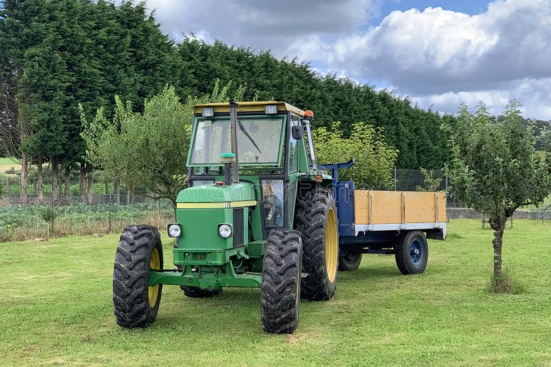 Tractor with Trailer in the Garden on Green Grass, Agricultural Work ...