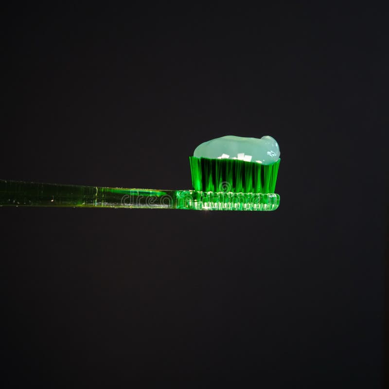 Green Transparent Toothpaste on Green Toothbrush on Black Background ...