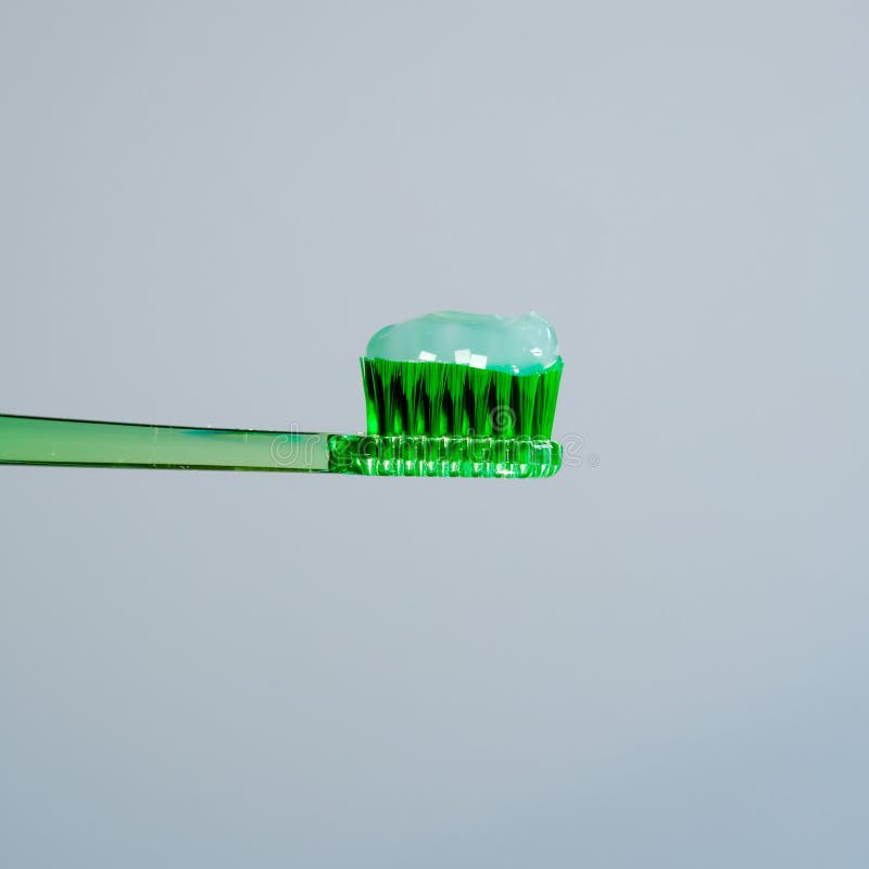Green Transparent Toothpaste on Green Toothbrush on Gray Background ...