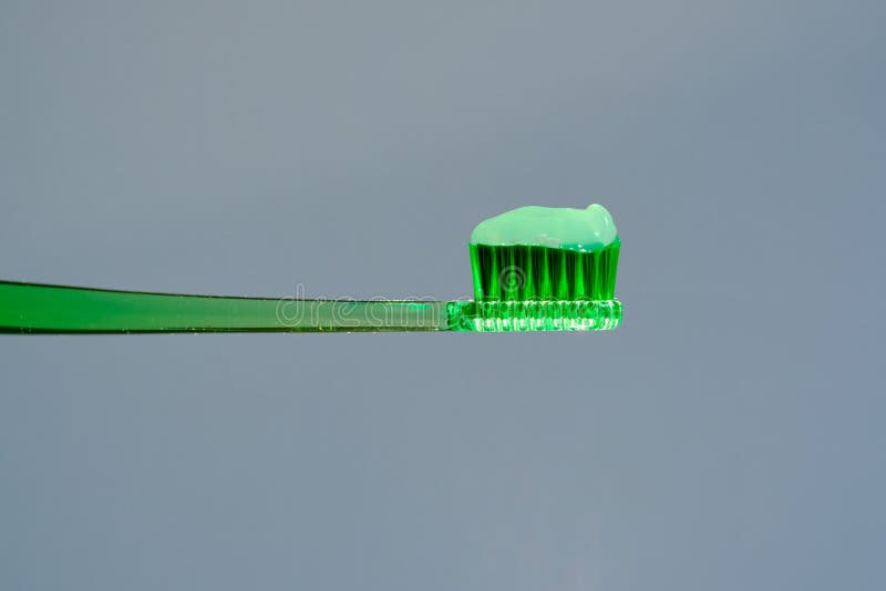 Green Transparent Toothpaste on Green Toothbrush on Gray Background ...