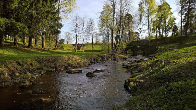 Green Valley with a Small River and an Ancient Stone Bridge Across it ...