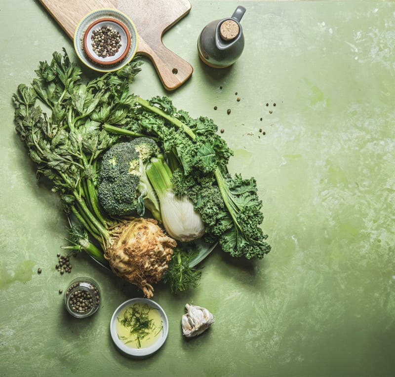 Green Vegetables on Table Background with Cutting Board and Ingredients ...