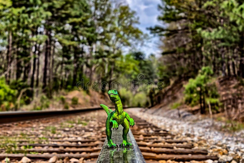 Green Velociraptor Dinosaur Walking on Rail Railroad Tracks Stock Image ...