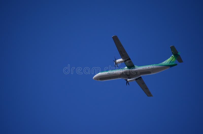 Green and White Double Helix Regional Airplane Flying Left Editorial ...