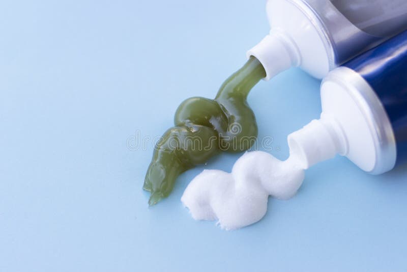 Green and White Toothpaste Squeezed Out of Tubes on Blue Background ...