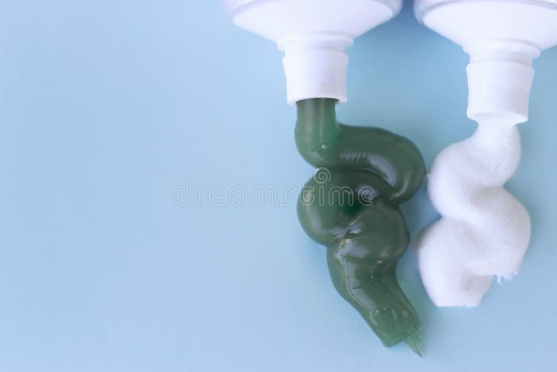 Green and White Toothpaste Squeezed Out of Tubes on Blue Background ...