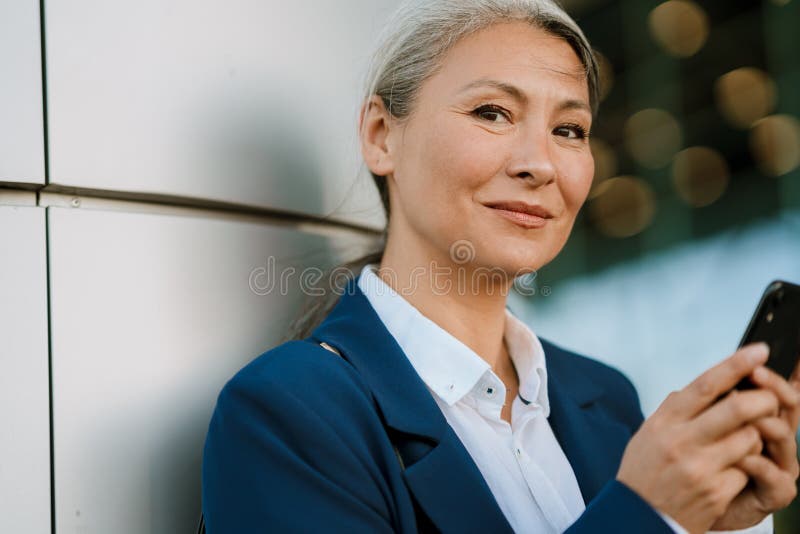 Grey Asian Woman Smiling while Using Mobile Phone Stock Image - Image ...