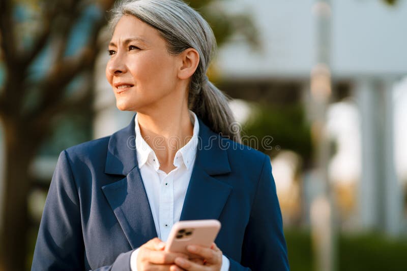 Grey Asian Woman Wearing Blue Jacket Using Mobile Phone Stock Photo ...