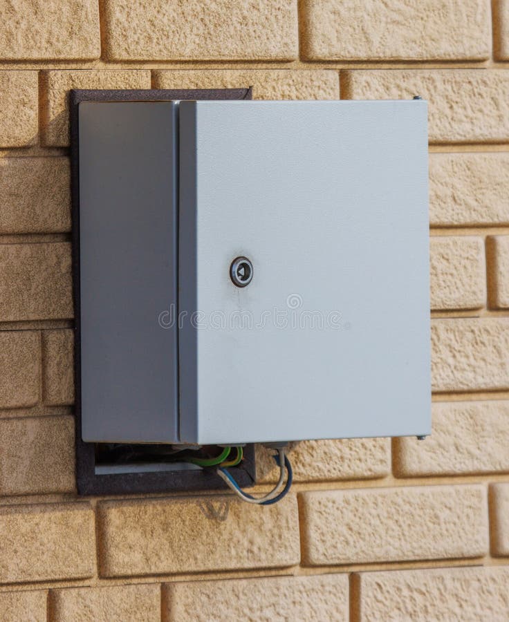A Grey Box with a Silver Door Sits on a Brick Wall Stock Photo - Image ...