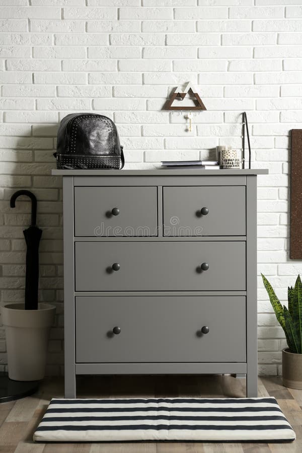 Grey Chest of Drawers Near Brick Wall Indoors Stock Photo - Image of ...