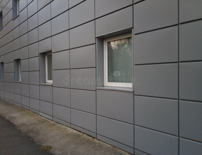 Grey Facade with Small Square White Windows Stock Image - Image of grey ...