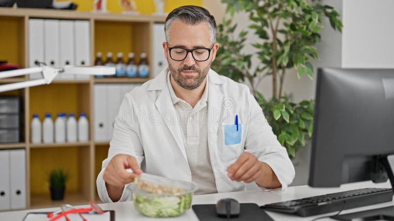 Grey-haired Man Doctor Eating Salad while Work at the Clinic Stock ...