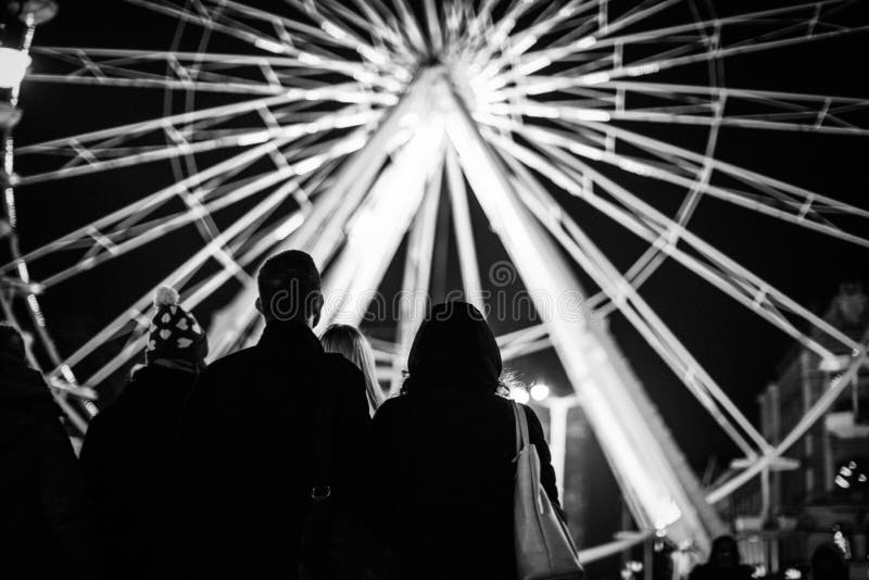 Grey Scale Shot of a Group of People Standing in Front of a Merry Go ...