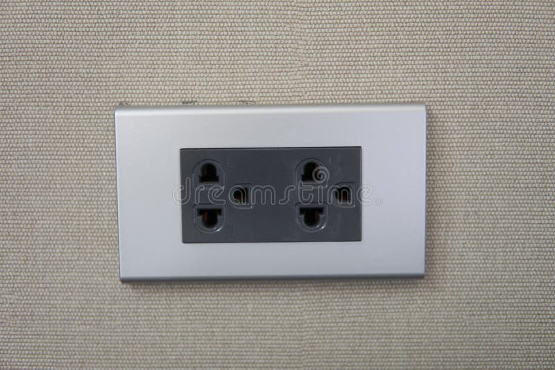 Grey Universal Electricity Sockets Plug on a Yellow Wall. Stock Image ...