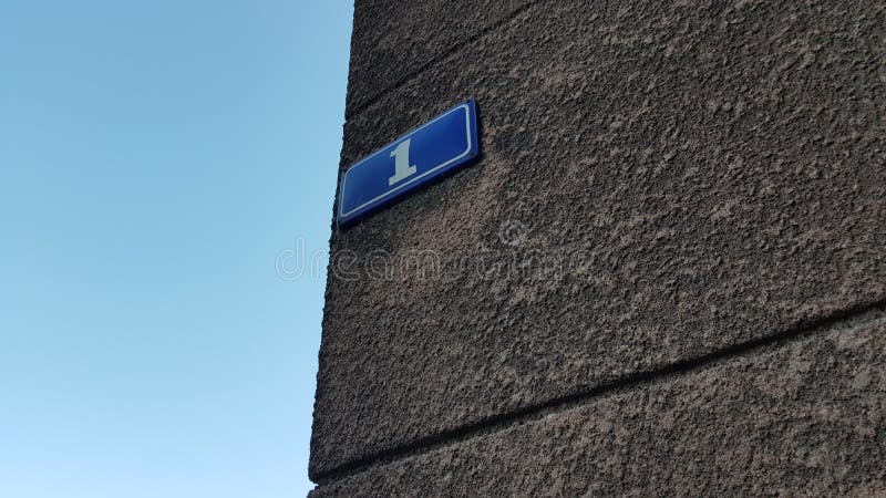 Grey Wall on Blue Sky Background with Number One on it Stock Photo ...