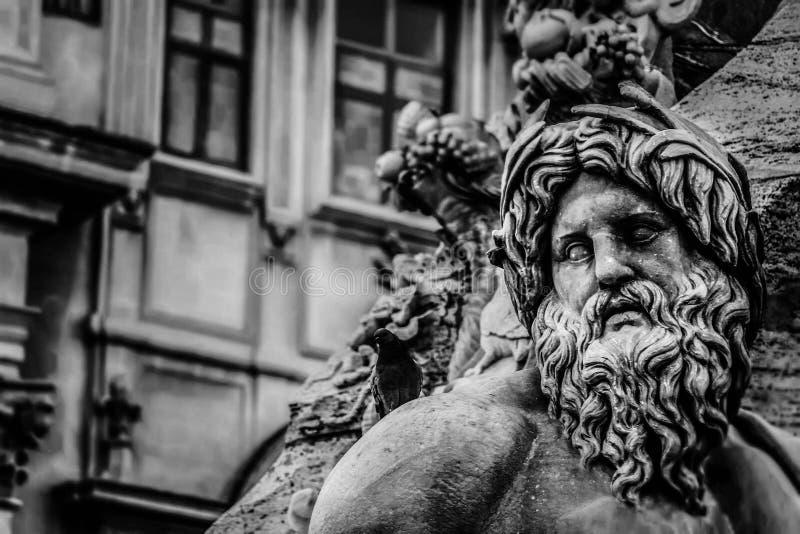 Greyscale of an Antique Statue with Blurred Buildings in the Background ...