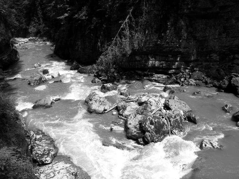 Greyscale High Angle Shot of a River Flowing among the Rocks and Cliffs ...