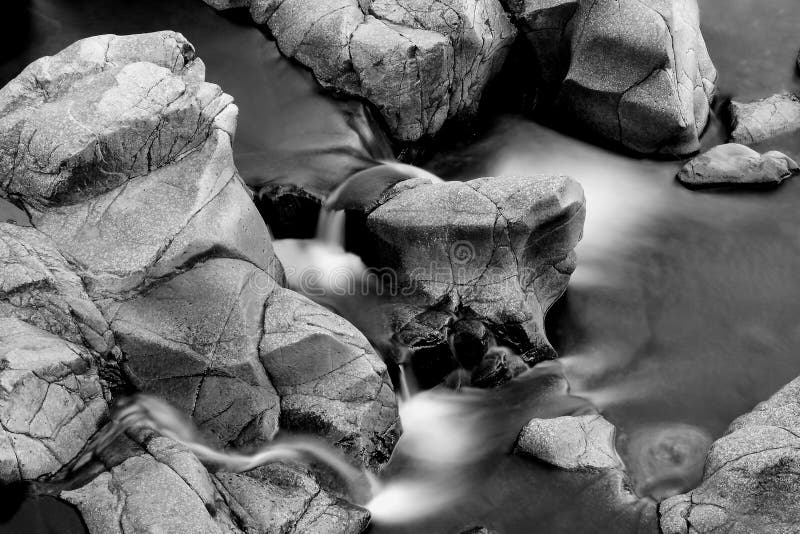 Greyscale of a River Covered in Granite Boulders Under the Sunlight in ...