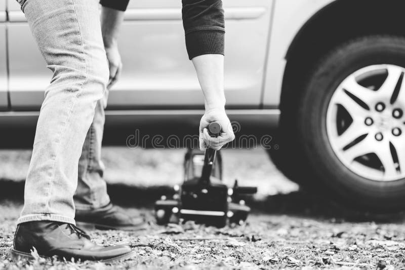 Greyscale Shot of a Mechanic Trying To Fix a Car with Special Tools ...