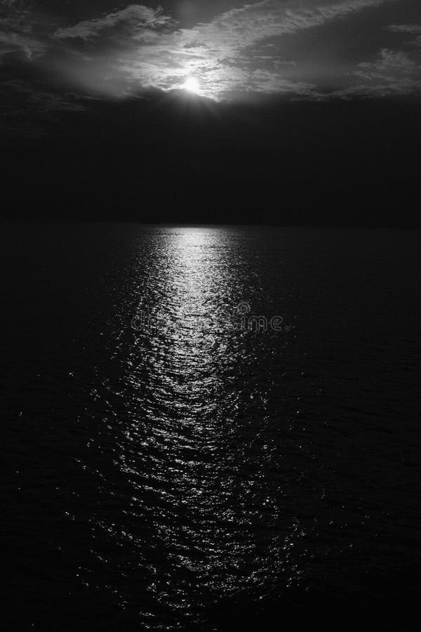 Greyscale Shot of the Sunset, with the Reflection of the Sun Rays in ...