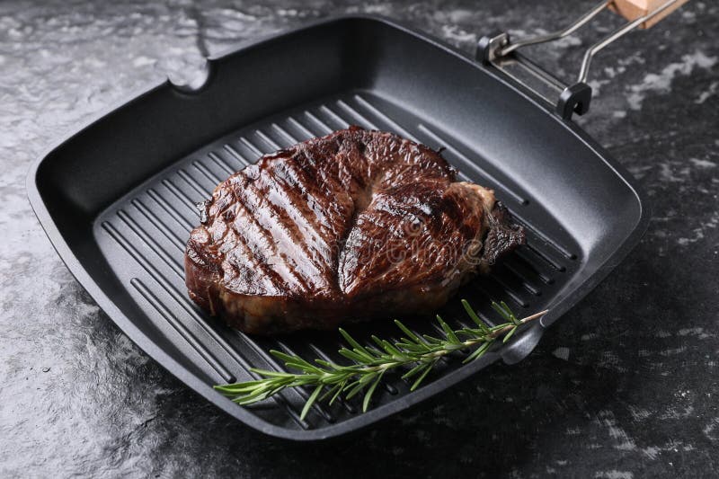 Grill Pan with Delicious Fried Beef Meat and Rosemary on Grey Textured ...