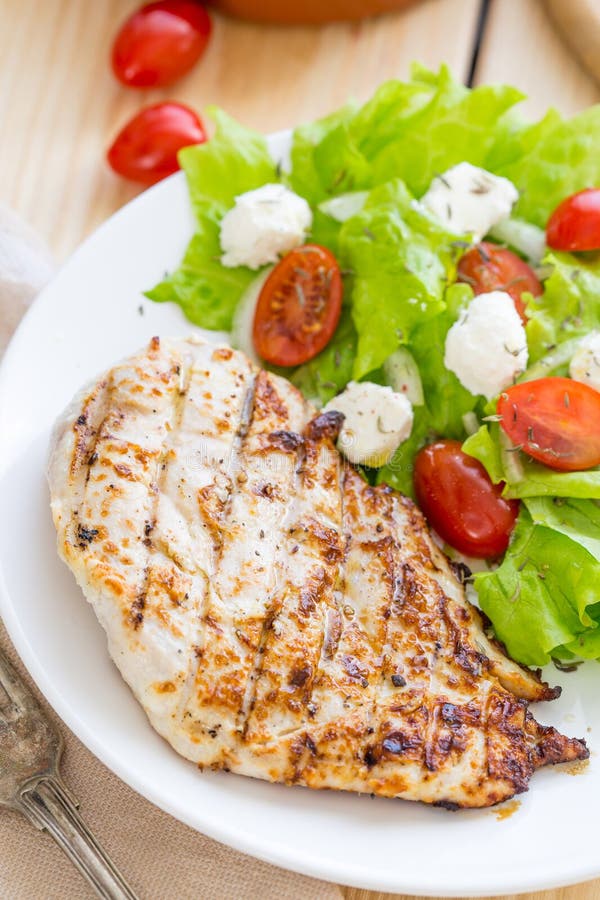 Grilled Chicken Breast with Fresh Vegetables on Light Wooden Background ...