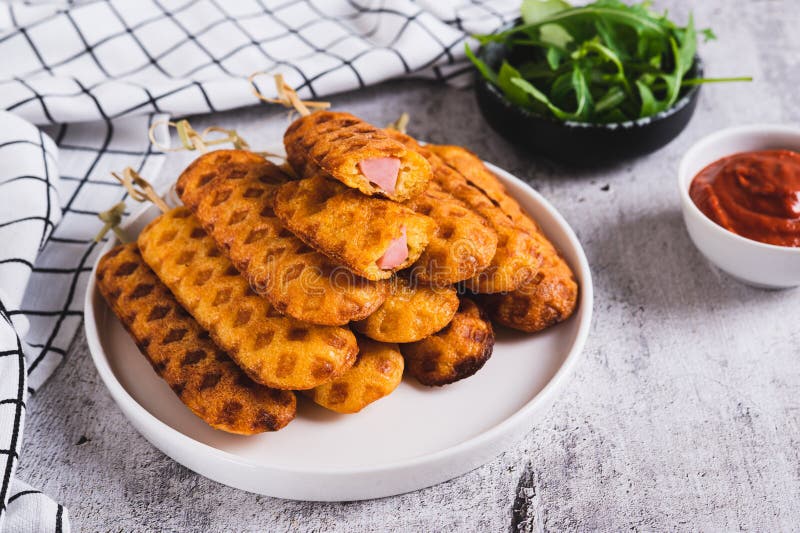 Grilled Corn Dogs with Sausage on a Plate and Ketchup on the Table ...
