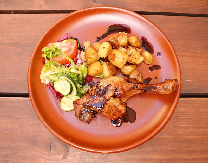 Grilled Duck Leg with Potatoes and Fresh Salad on a Ceramic Plate Stock ...
