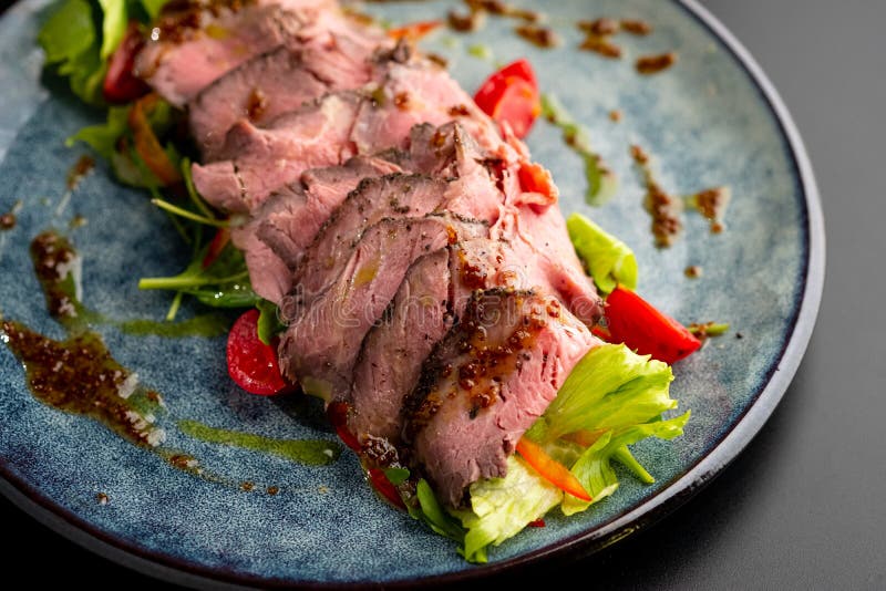 Grilled Duck Meat with Salad on a Grey Plate on a Black Background ...